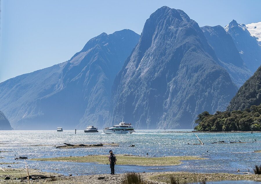 Cliffs reflected in calm Milford Sound water