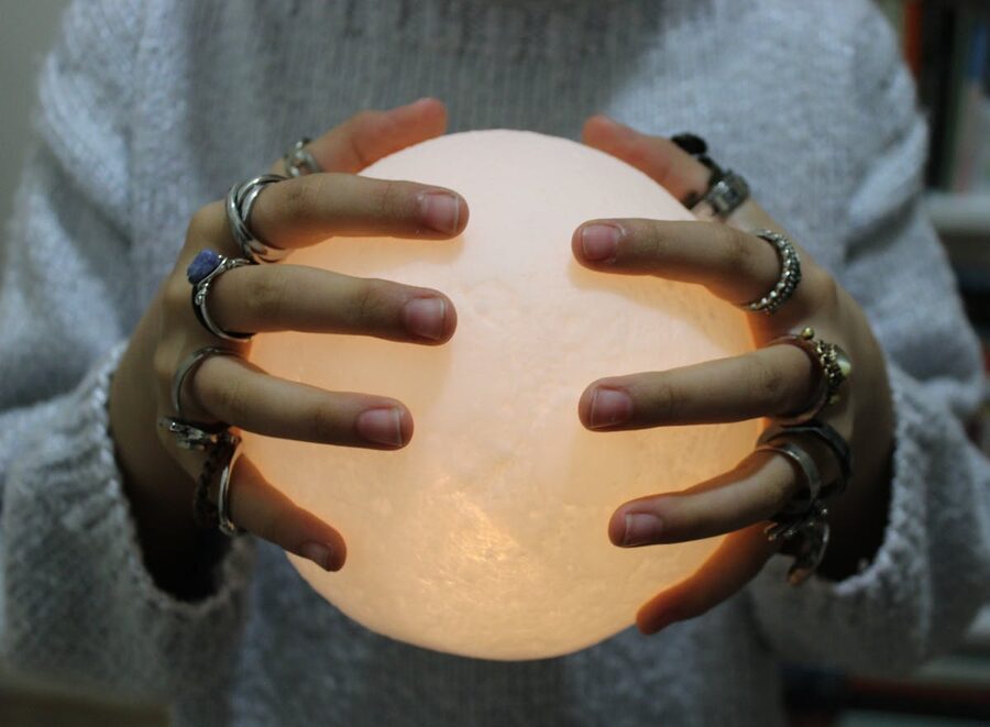 Hands holding glowing crystal ball mystical atmosphere
