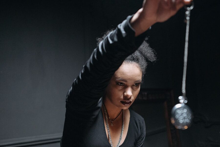 Woman performing mystical ritual with pendant atmospheric