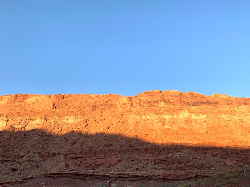 Moab red rock formations at sunrise against blue sky