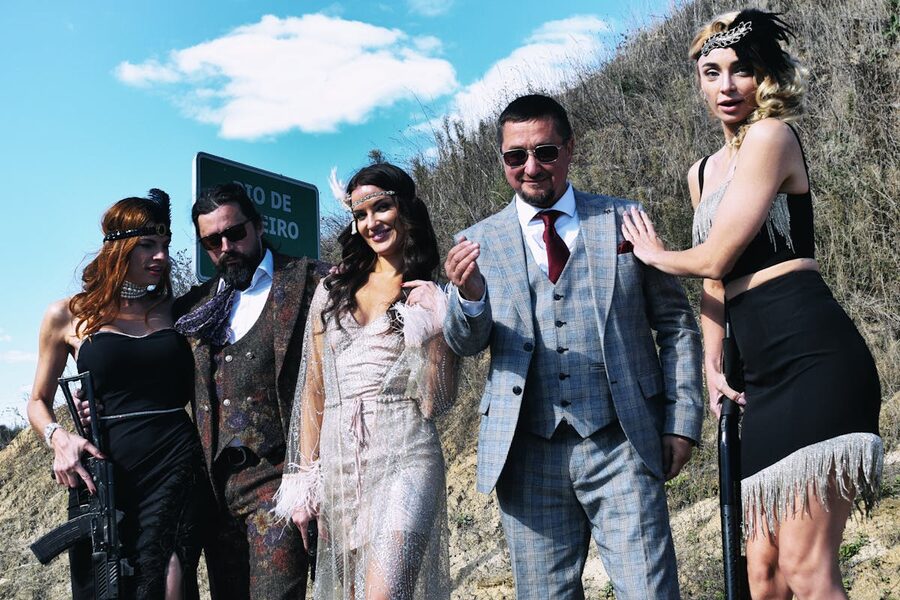 Group in Gatsby-era gangster costumes outdoors vintage fashion