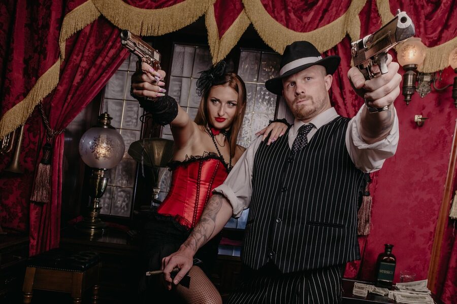 Retro mafia gangster couple with pistol and weapon