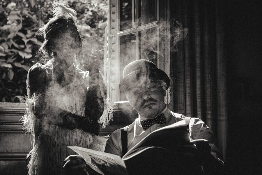 Couple in vintage fashion flapper dress and man with hat black and white