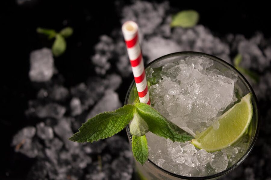 A tall mojito cocktail with mint leaves, lime slice, and crushed ice