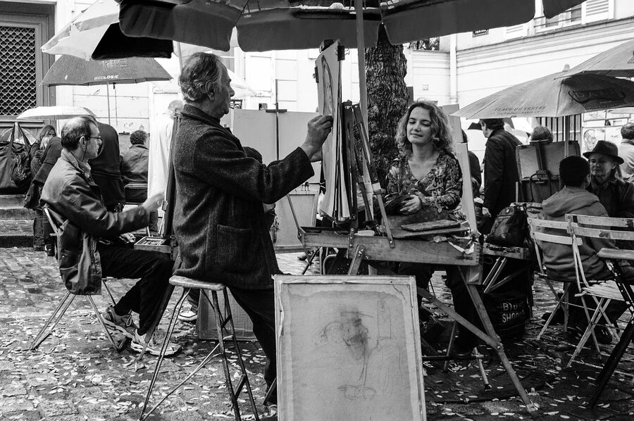 Artist painting in Place du Tertre Montmartre with tourists