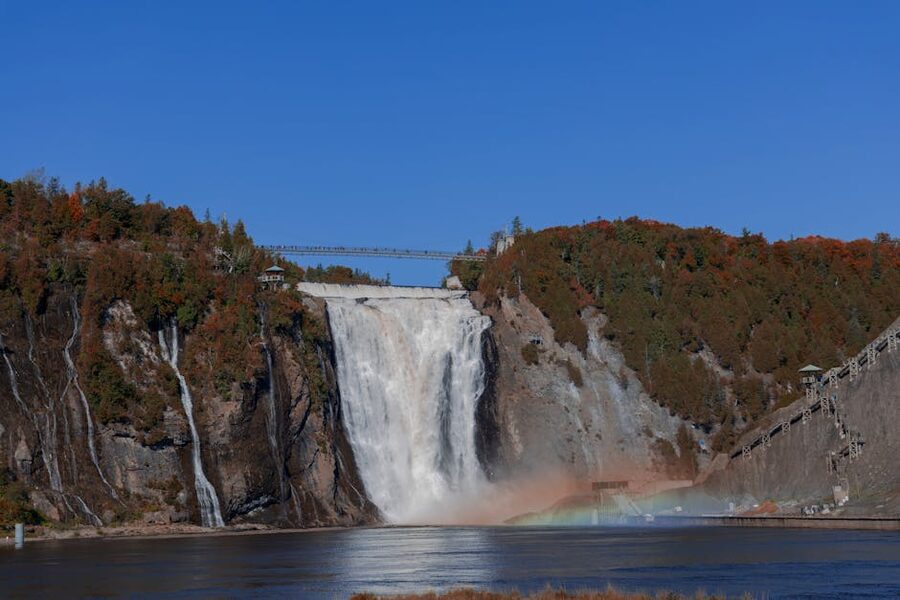 Montmorency Falls under a clear blue sky with autumn foliage