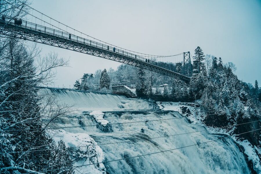 Snowy winter view of Montmorency Falls with suspension bridge