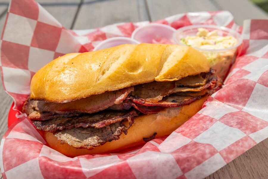 Brisket sandwich in a red checkered basket with coleslaw