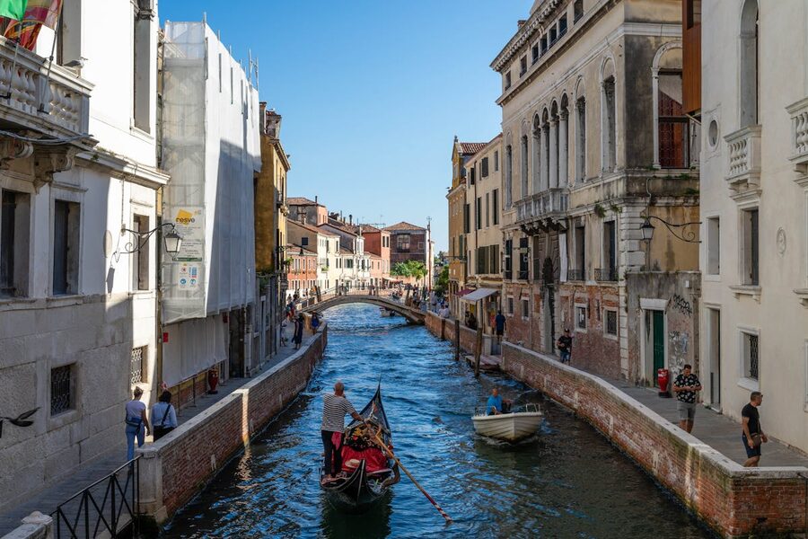 Gondola navigating narrow canal in Venice Italy traditional architecture