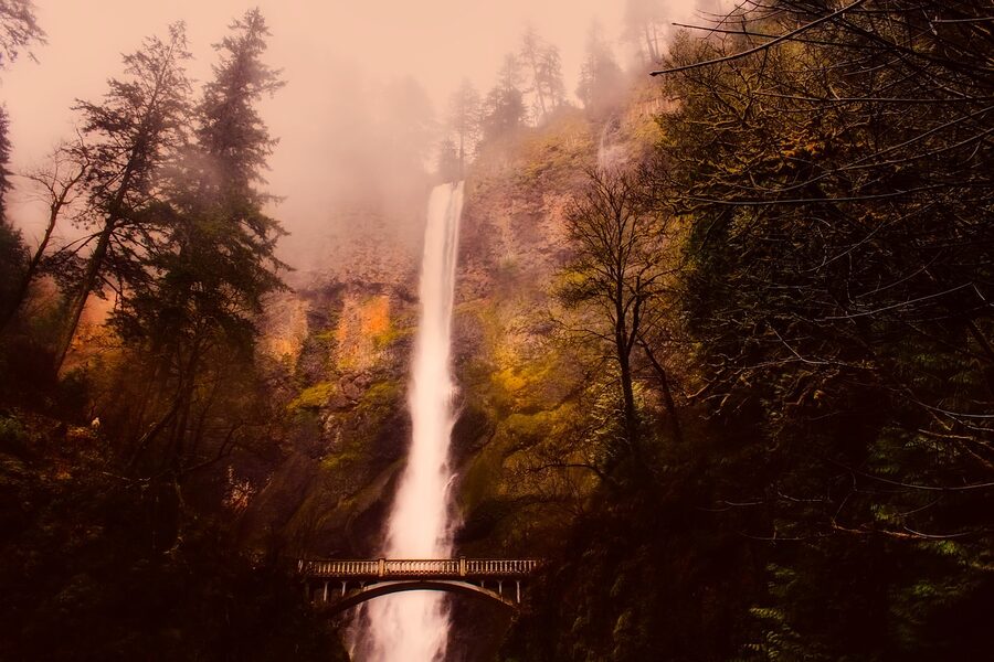 Multnomah Falls with fog and forest around the bridge