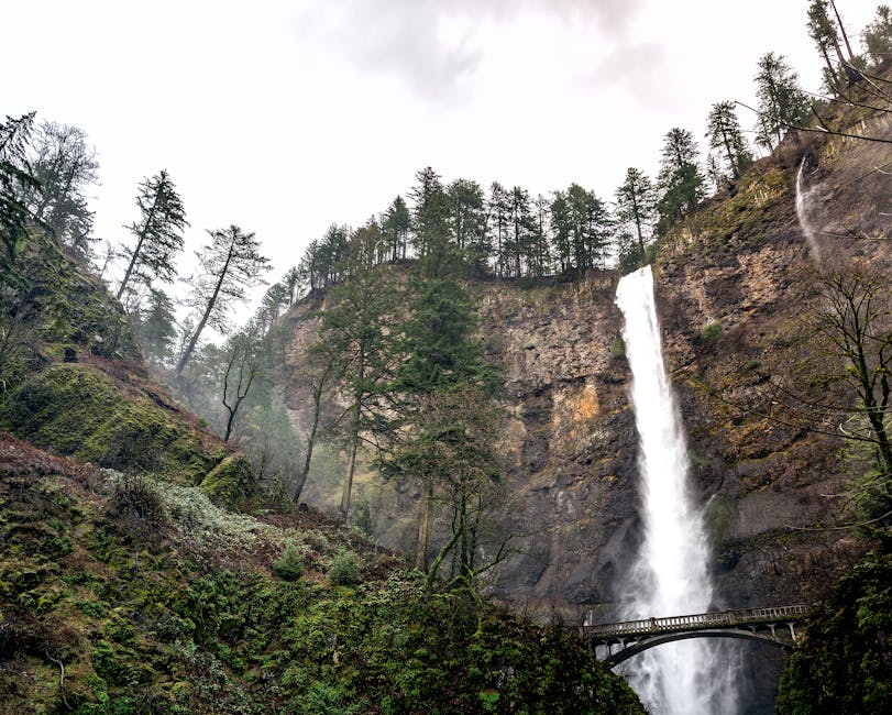Multnomah Falls with rocky cliffs on an overcast day
