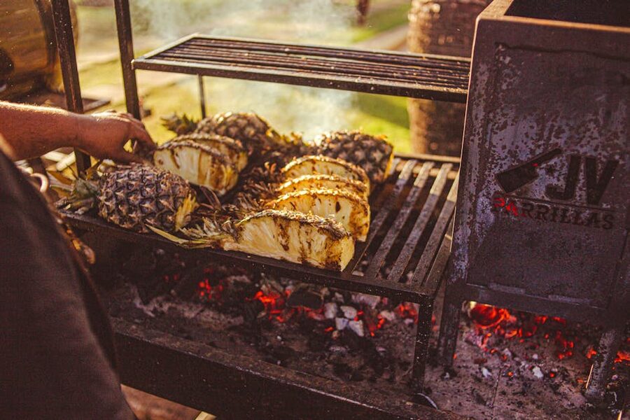Pineapple grilling over open charcoal at a luau buffet