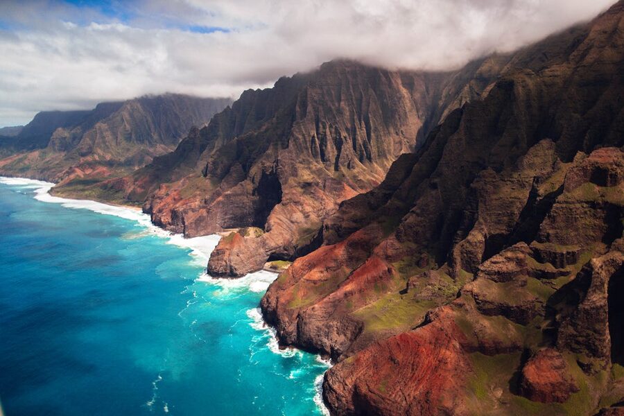 Aerial view of rugged Na Pali Coast with dramatic cliffs and turquoise water