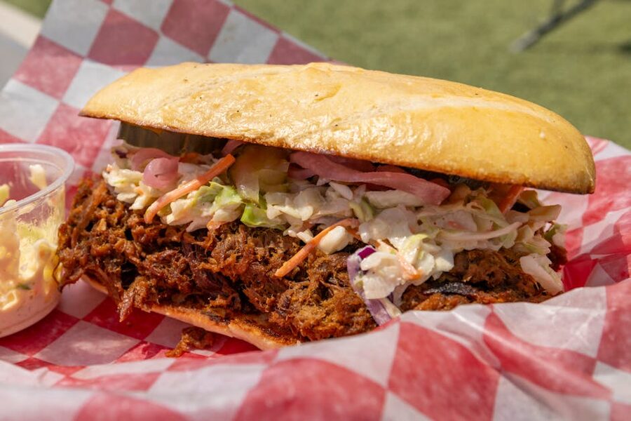 Pulled pork sandwich with coleslaw on checkered paper