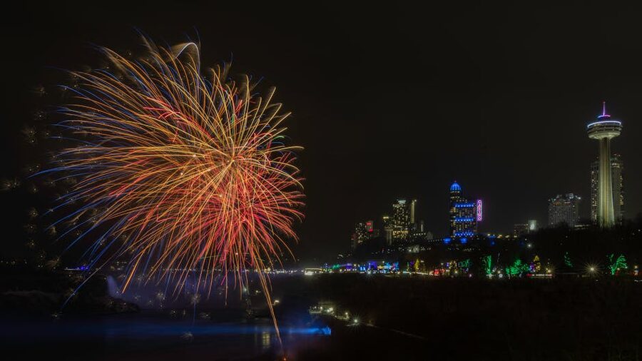 Fireworks above Niagara Falls and Skylon Tower skyline at night