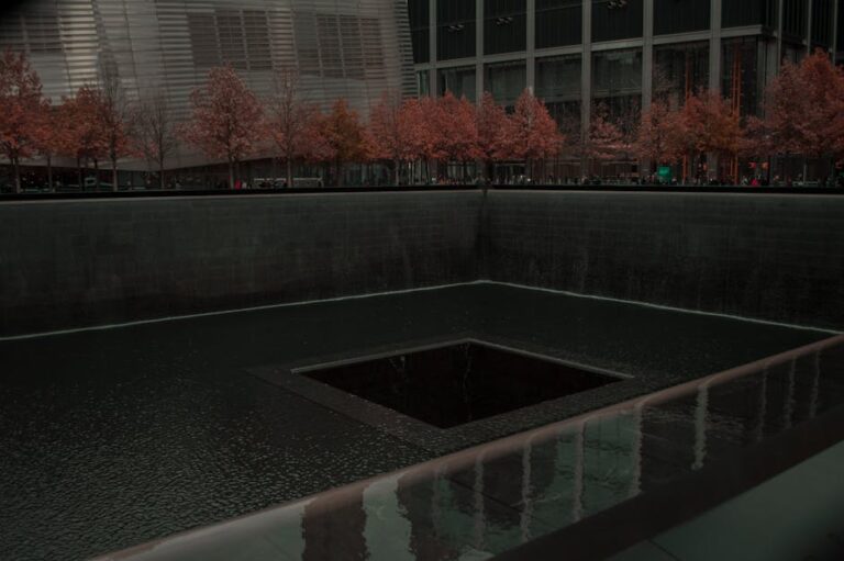 9/11 Memorial Pool with autumn trees and urban backdrop