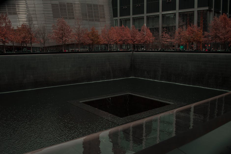 9/11 Memorial Pool with autumn trees and urban backdrop