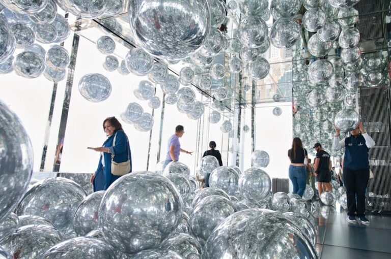 Visitors exploring reflective art installation with mirrored spheres