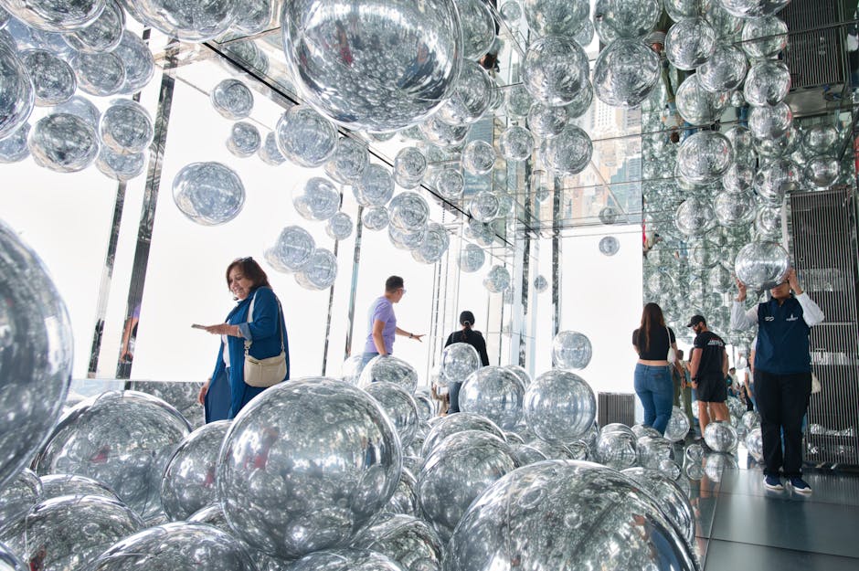 Visitors exploring reflective art installation with mirrored spheres