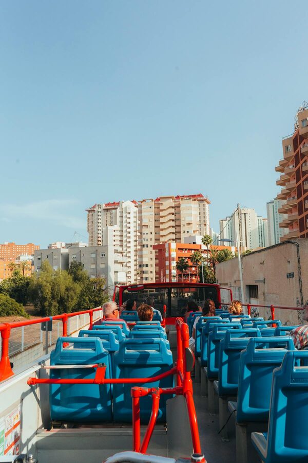 Open top sightseeing bus tour through city buildings