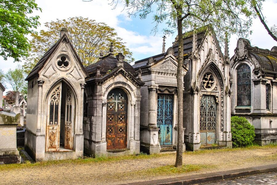 Gothic mausoleums lining a Paris cemetery avenue