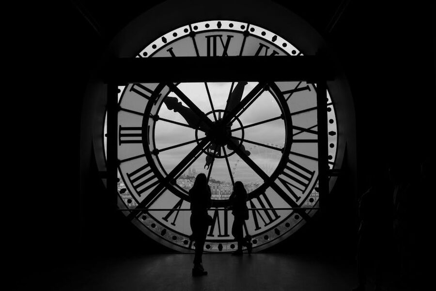 Visitors in silhouette behind the giant Musee d'Orsay clock window