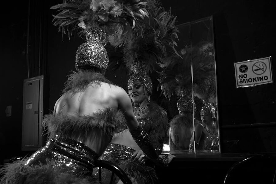 Cabaret dancer in feathered headdress preparing backstage