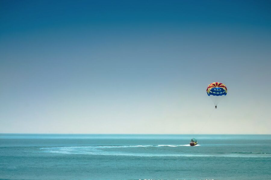 Parasailing experience over the vast blue ocean under clear sky