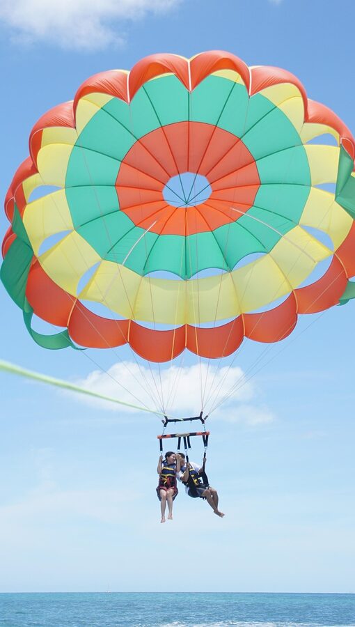 Parasailing over the ocean with parachute as a water sport