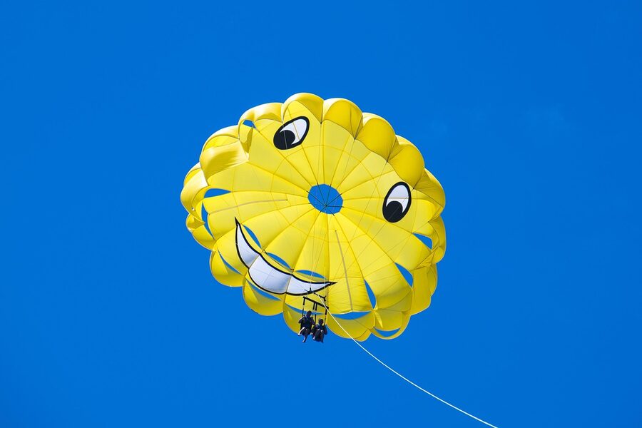 Parasailing parachute floating over blue sea