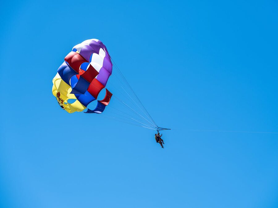 Thrilling parasailing experience against a clear blue sky