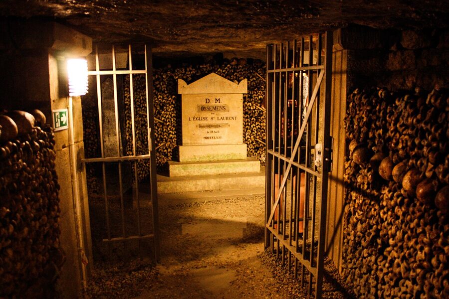 Stacked skulls and femurs inside a passage of the Paris Catacombs