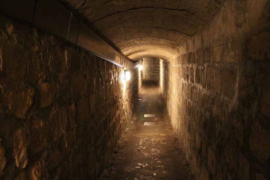 Empty stone-walled limestone quarry tunnel section before the Paris Catacombs ossuary