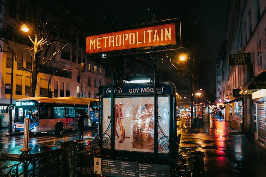 Wet Paris street and Métropolitain entrance at night