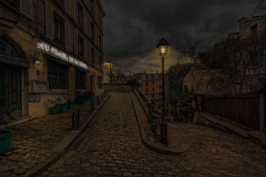 A French streetlight glowing on a Paris street at night