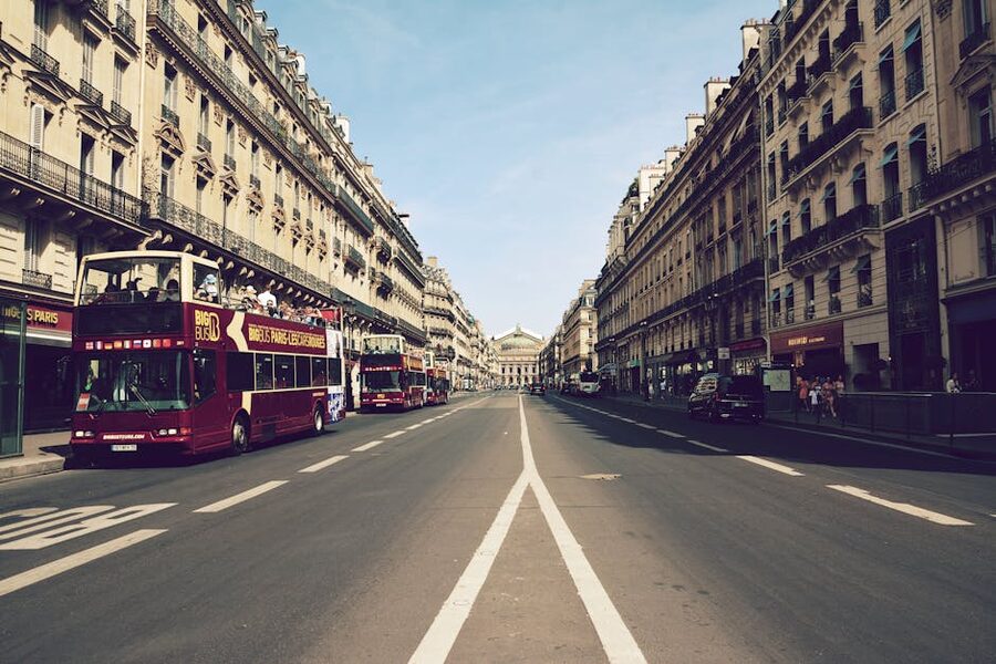 Sightseeing buses on Haussmann Boulevard in Paris with Palais Garnier in view
