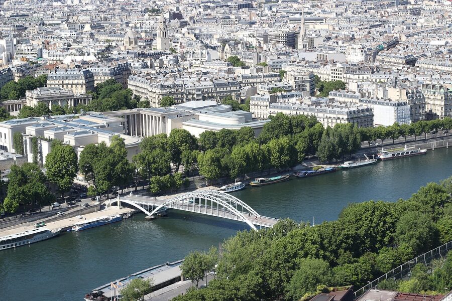 Seine River bridge with a passing tour boat and Eiffel Tower view, Paris