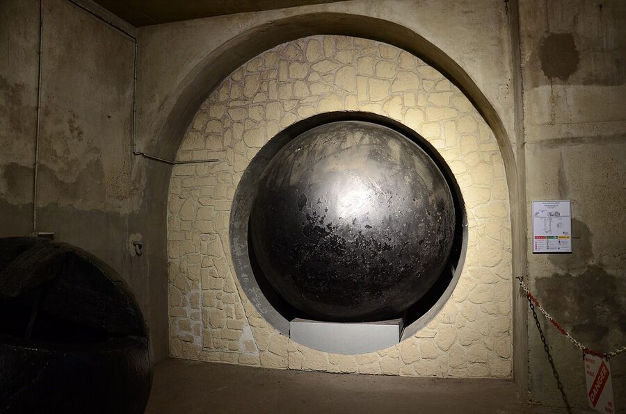 Pipes and signage running overhead in the Paris Sewer Museum tunnels