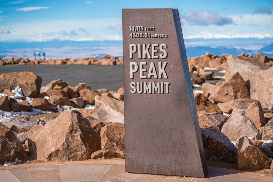 Pikes Peak summit sign with rocky terrain