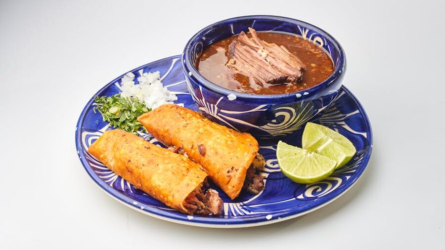 Birria tacos with consommé dip, onions and lime