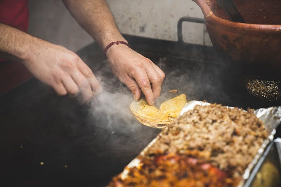 Taco vendor preparing tacos on a large grill in Puerto Vallarta