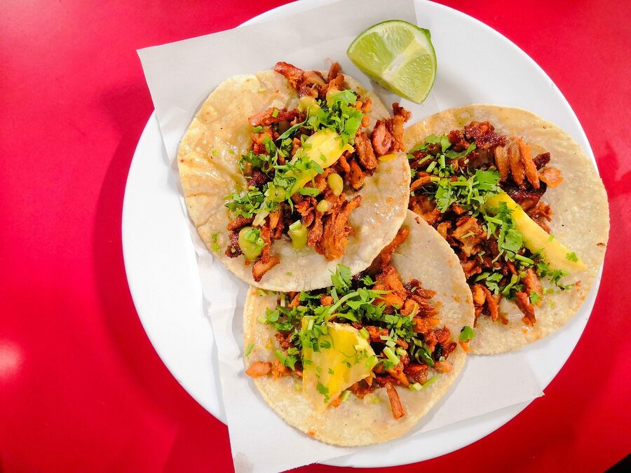 Plate of tacos al pastor with tortillas and pineapple