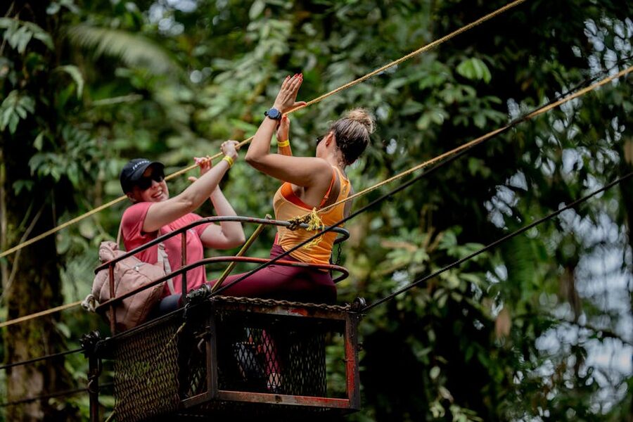 Two people enjoying a zipline through jungle