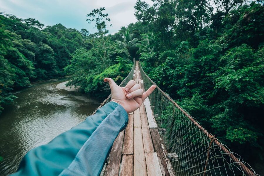Trekker crossing a wooden suspension bridge
