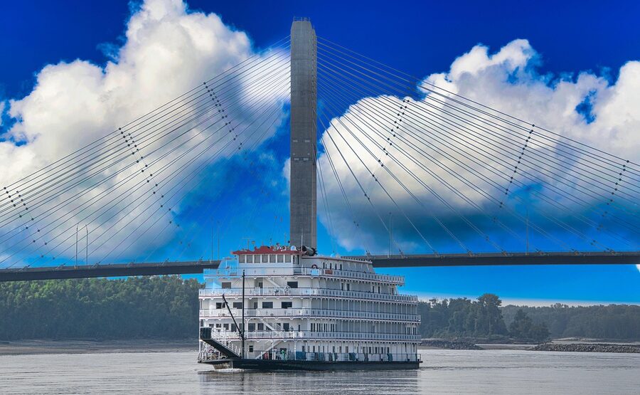Riverboat cruising on the Mississippi River near a bridge in New Orleans