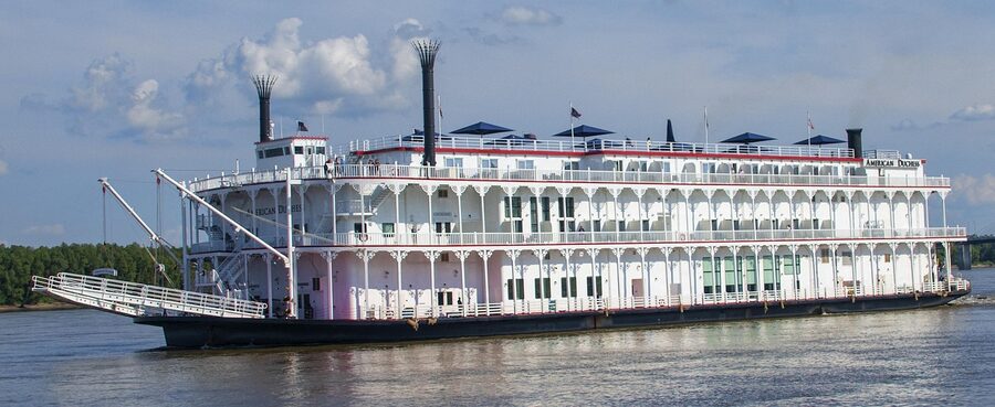 Vintage riverboat with paddle wheel docked on a river