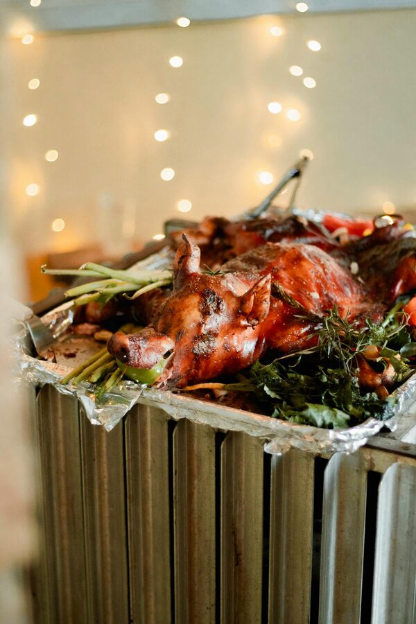 Succulent roasted whole pig garnished with fresh herbs and vegetables