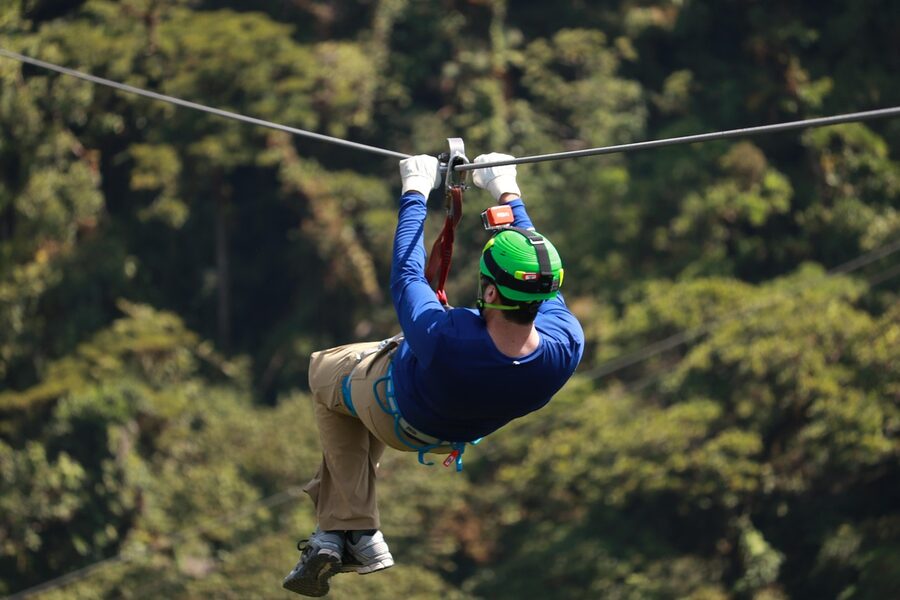 Rider on a zipline through a tree canopy