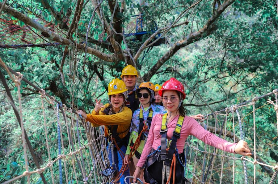 Group of adults crossing a swing bridge during a forest zipline tour
