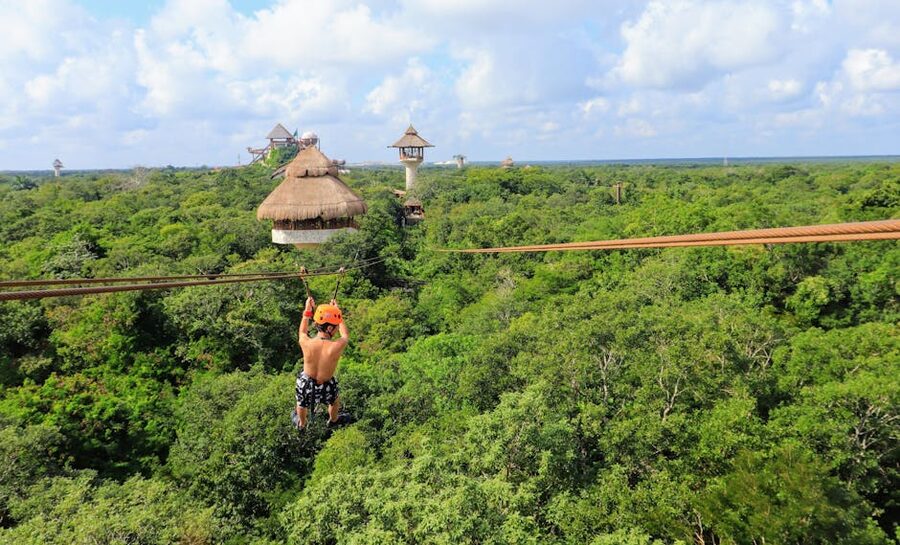 Tourist on a forest zipline mid-flight